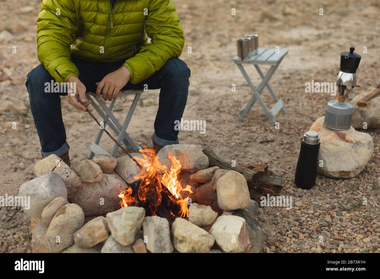 Front view of man preparing the fire of the camp Stock Photo - Alamy