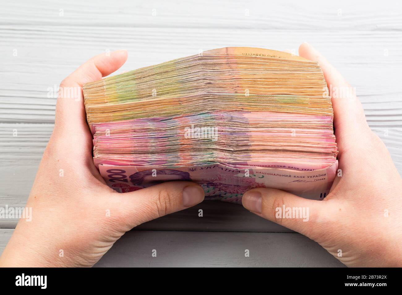 Money of Ukraine. Stack of ukrainian hryvnia banknotes in hands on ...