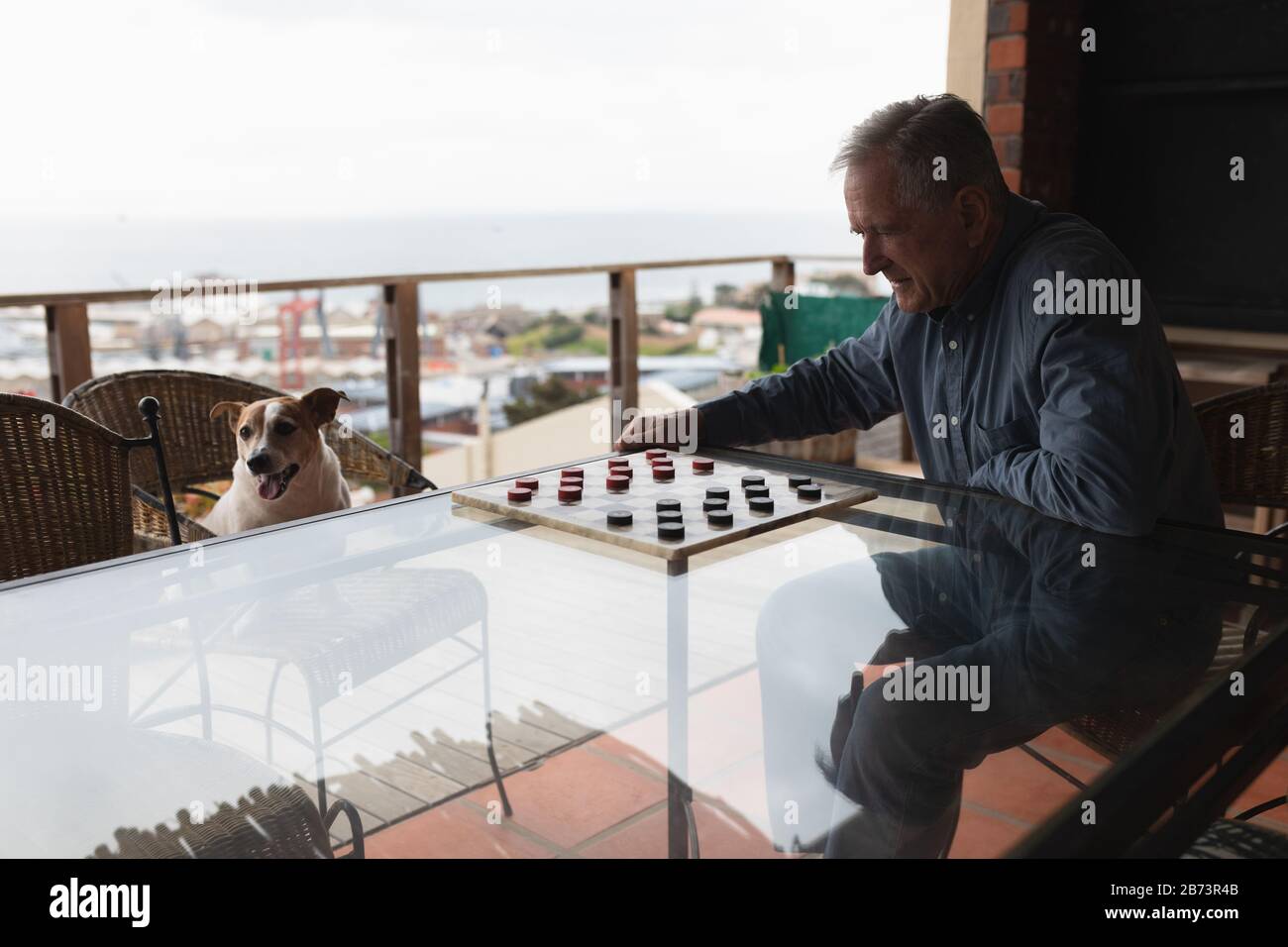 Senior man playing checkers on his terrace Stock Photo - Alamy