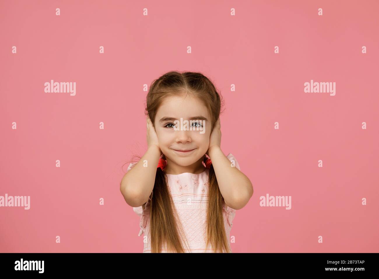 Little child girl covering her ear with her hand. I hear nothing Stock ...