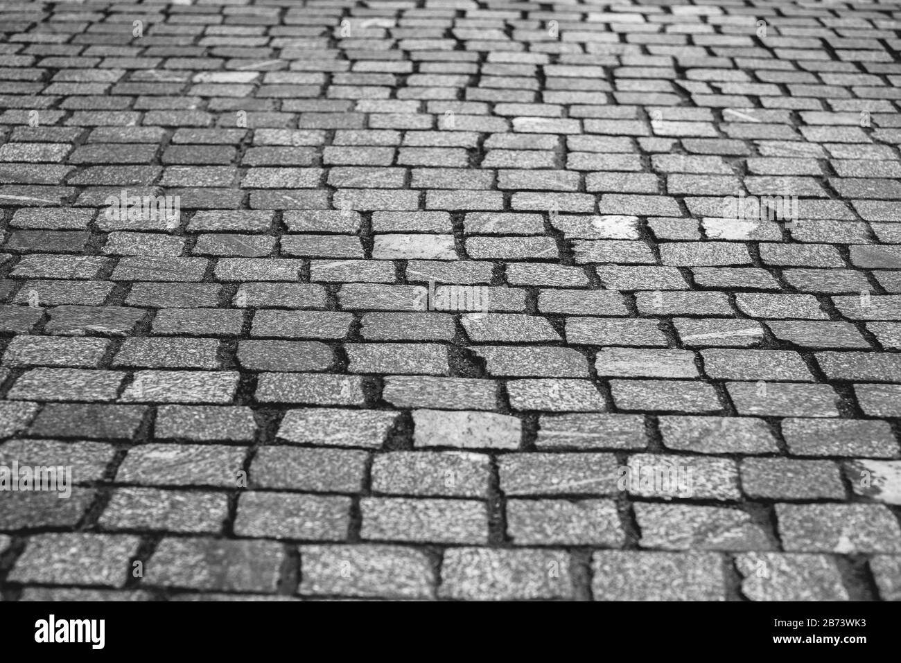 old European courtyard, paved with gray cobblestones. Pavers texture. A ...