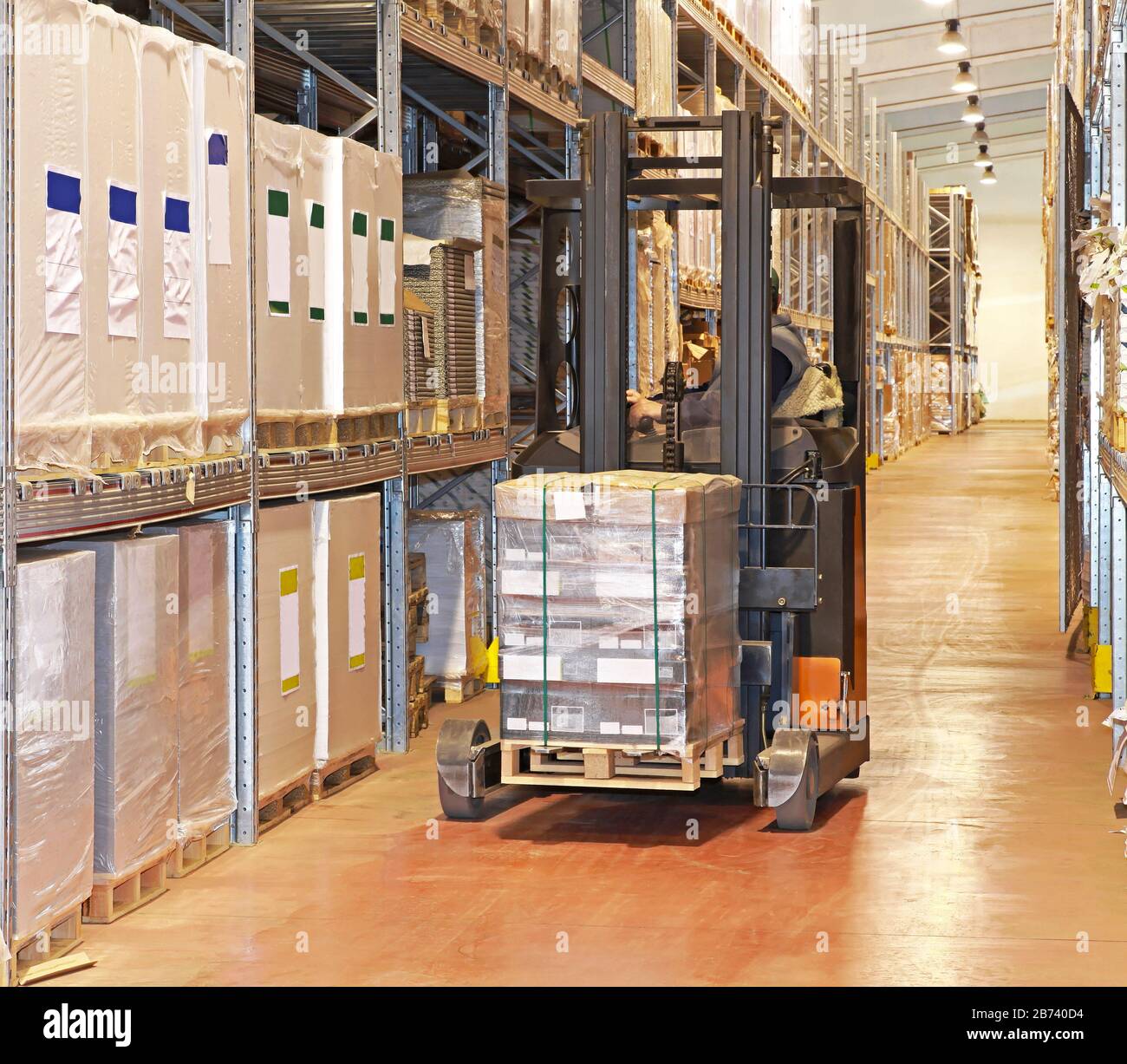 Loading Pallet With Forklift in Distribution Warehouse Stock Photo - Alamy