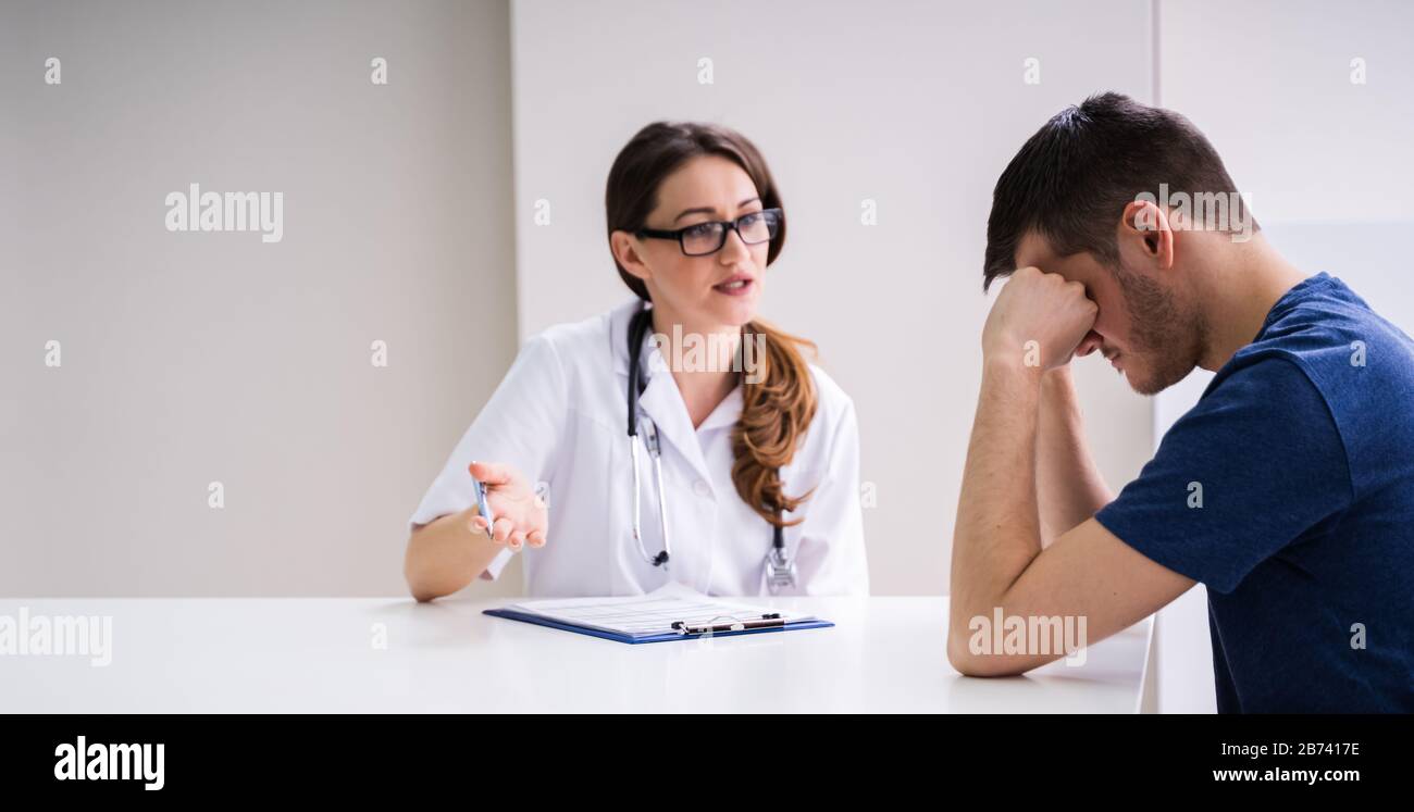Female Doctor Comforting Depressed Patient Sitting At Table Stock Photo ...