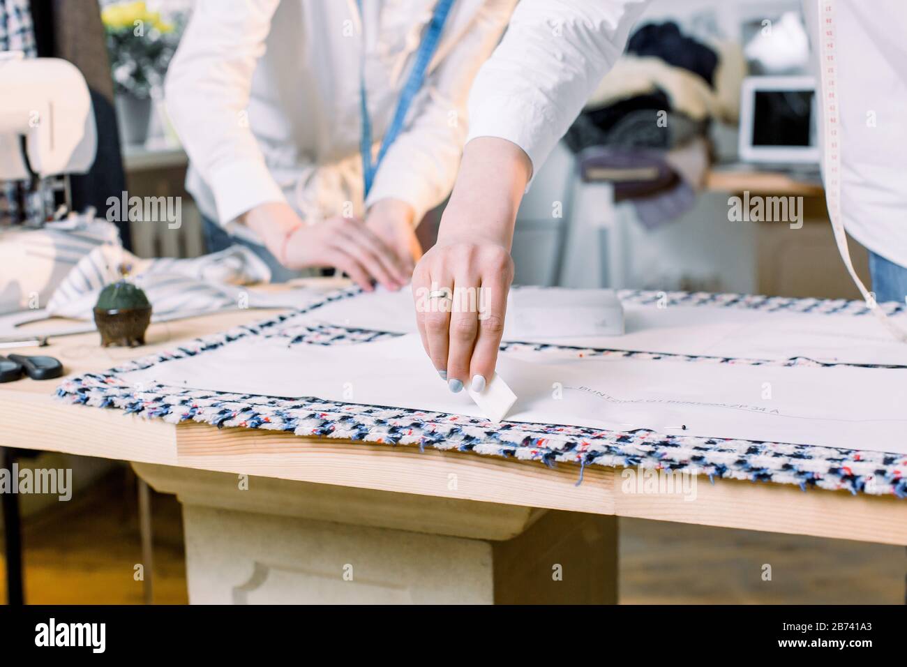 Close-up photo of women's hands of dressmaker working with sewing ...