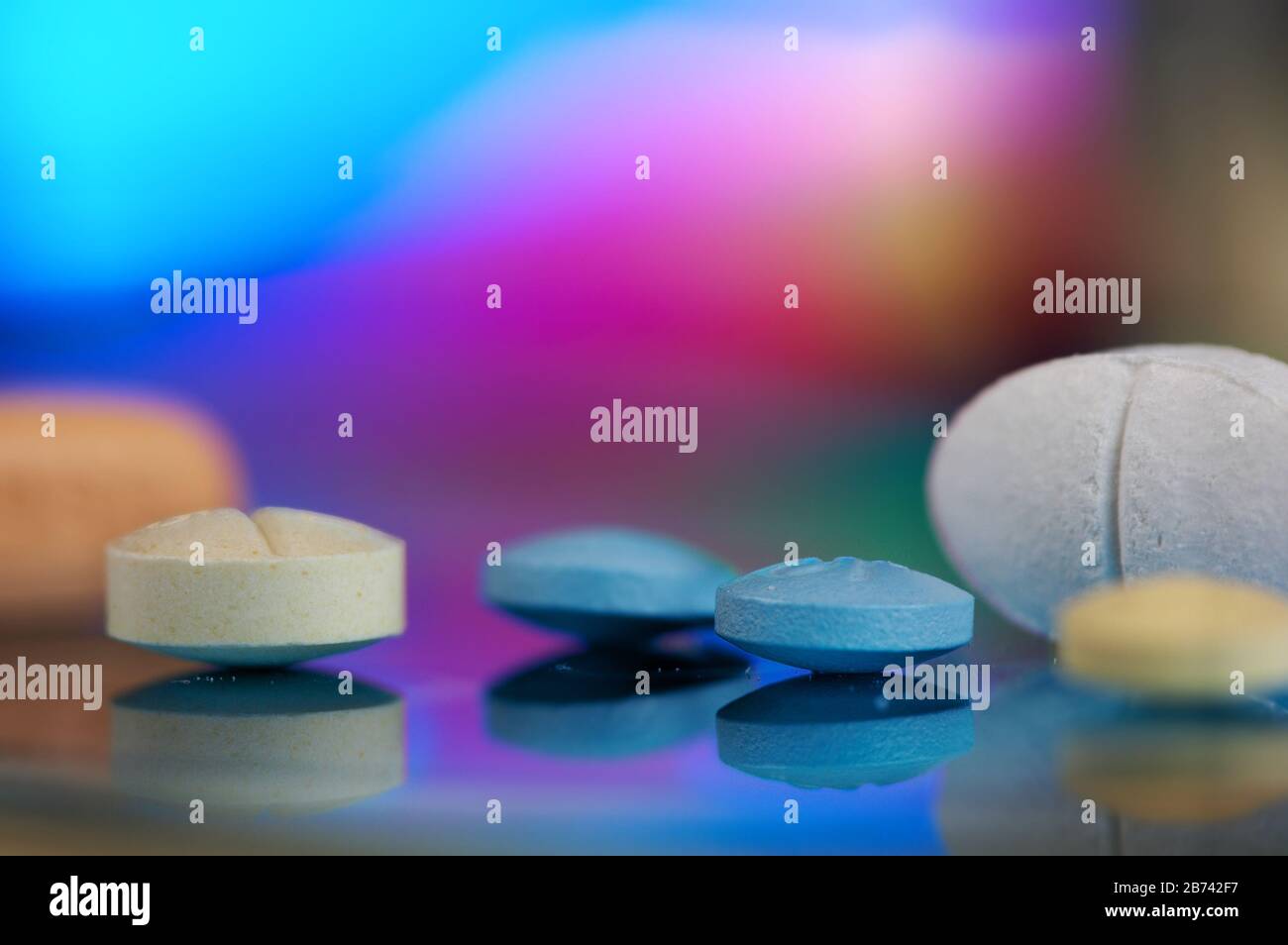 Small medicine tablets against a rainbow coloured background Stock ...