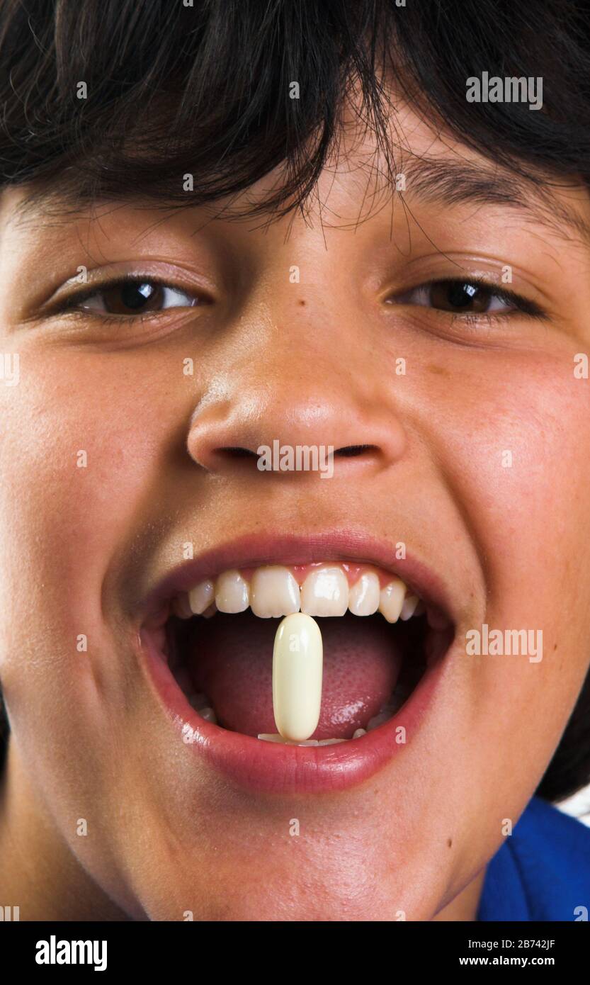 Smiling boy with a pill in his mouth Stock Photo - Alamy