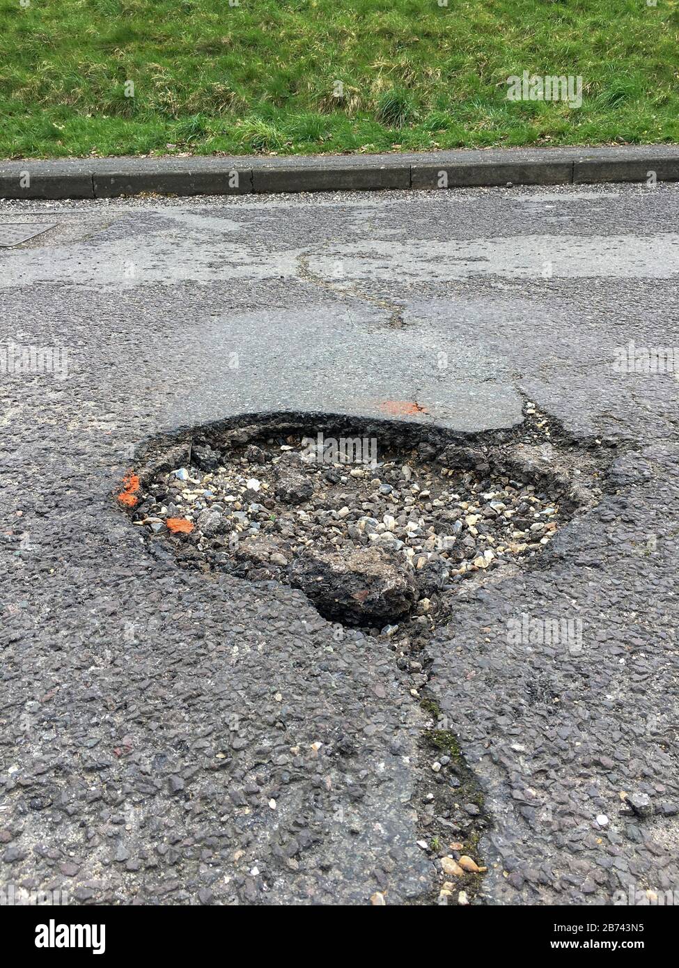 A large pothole forms in a road surface in Godalming, Surrey, England ...