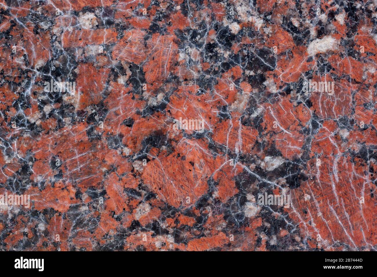 Reddish-brown granite texture with black and gray spots. Close up. Used ...