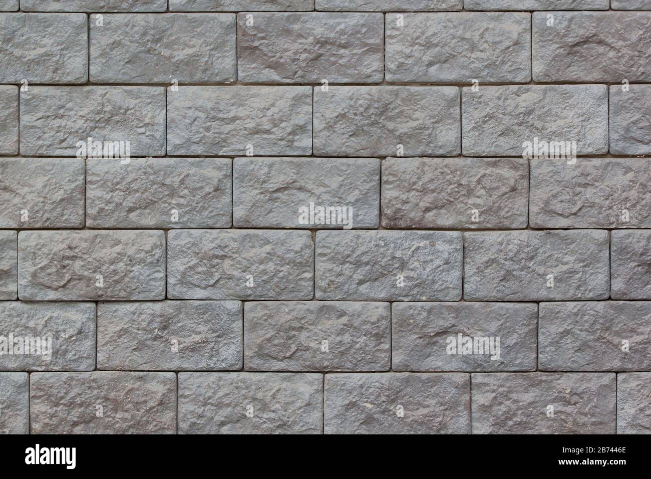 Brick wall with big gray bricks. Used as a background. Copy space for ...