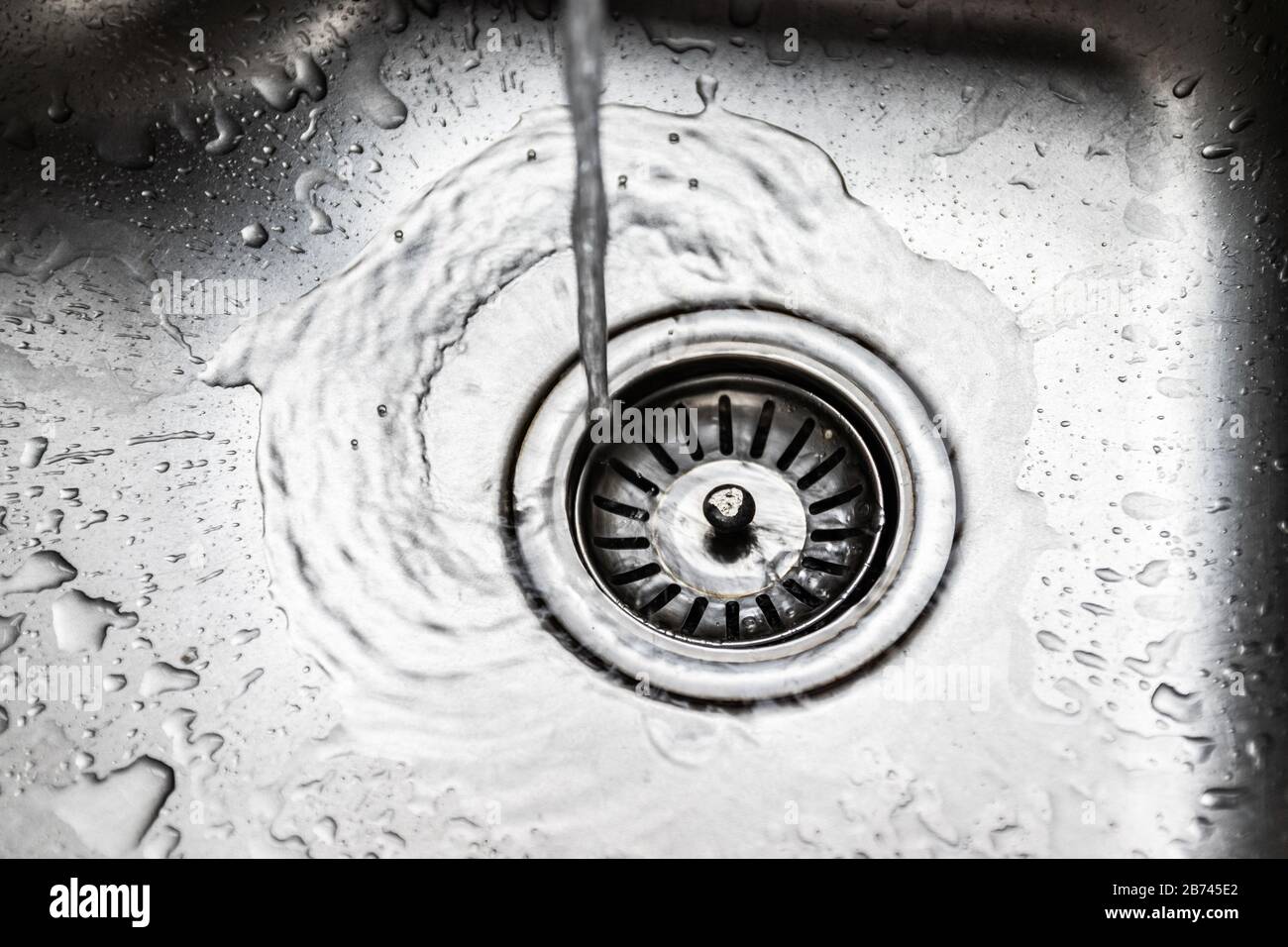 A stream of clean water flows into the stainless steel sink Stock Photo ...