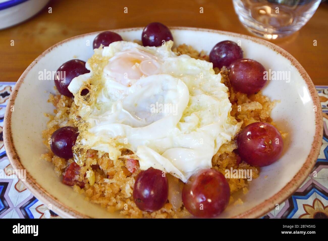 traditional plate of migas with egg and grapes Stock Photo - Alamy