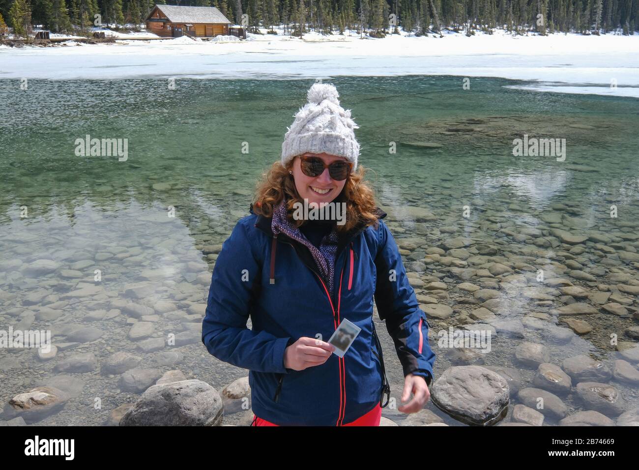 young woman has taken a polaroid photo at Lake Louise, she is waiting ...