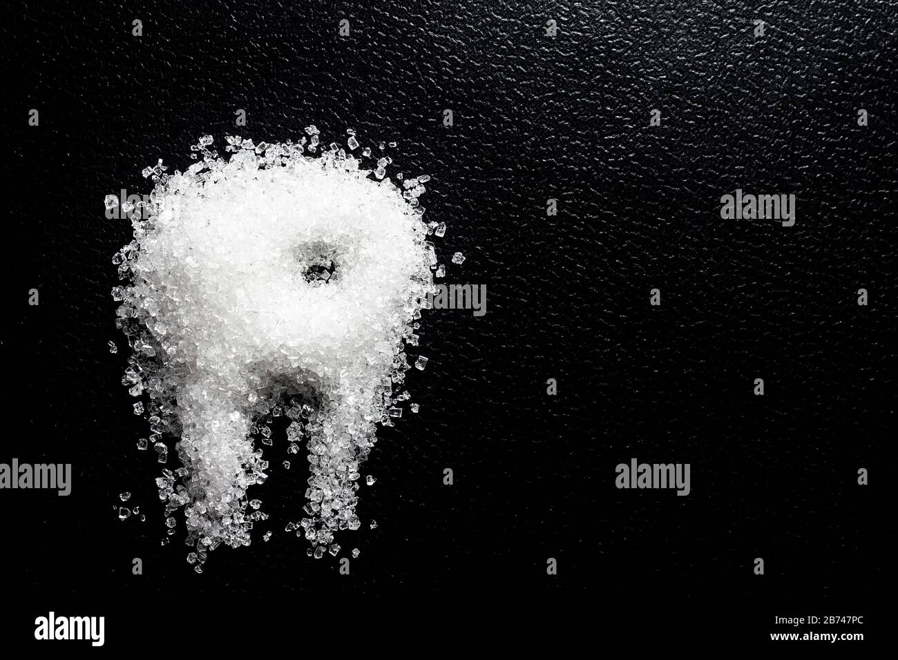 sugar decaying tooth character on a black background top view with copy ...