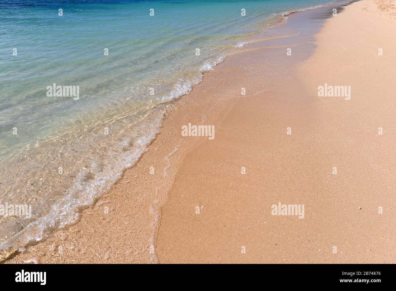 Sand and sea, waves lapping beach Stock Photo - Alamy