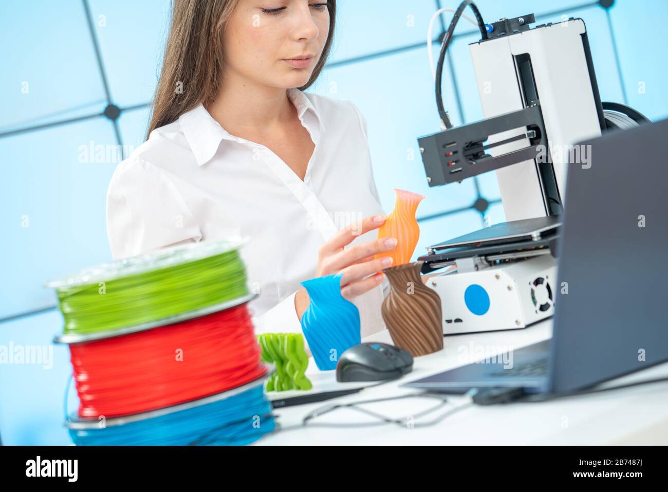 Young female designer works with a 3D printer in a design studio Stock ...