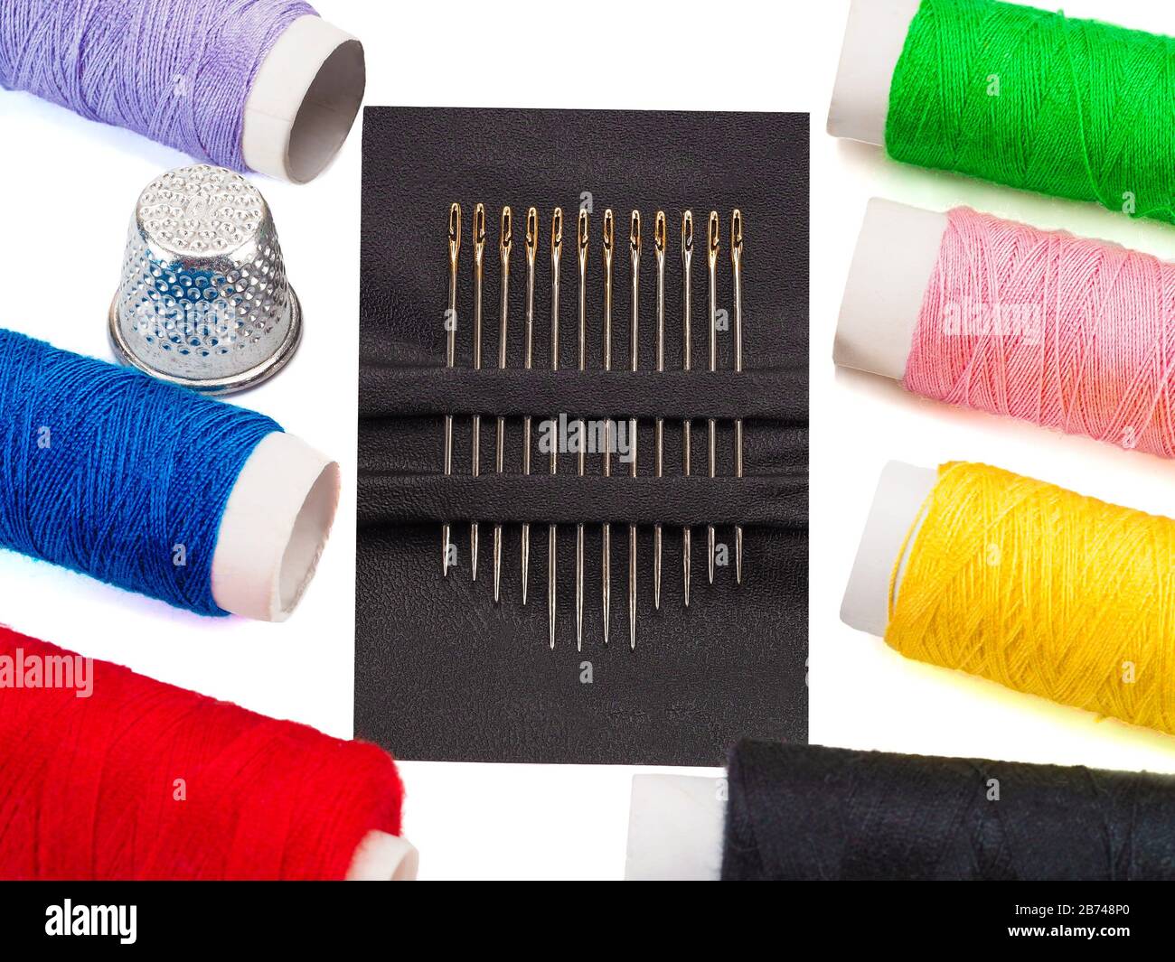 Set of steel sewing needles with golden needle's eyes, threads of ...