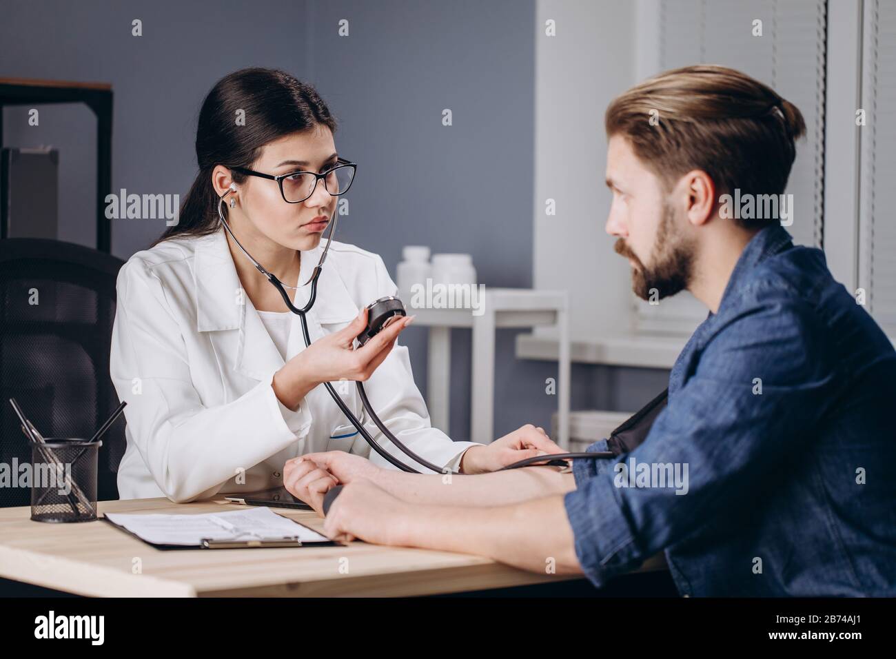 Pretty Female Physician Measuring Patient's Blood Pressure Stock Photo ...