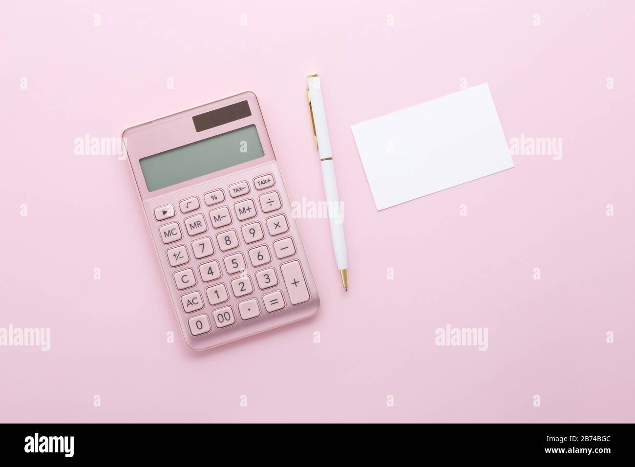 Pink gold calculator with pen and business card on pink background, top ...
