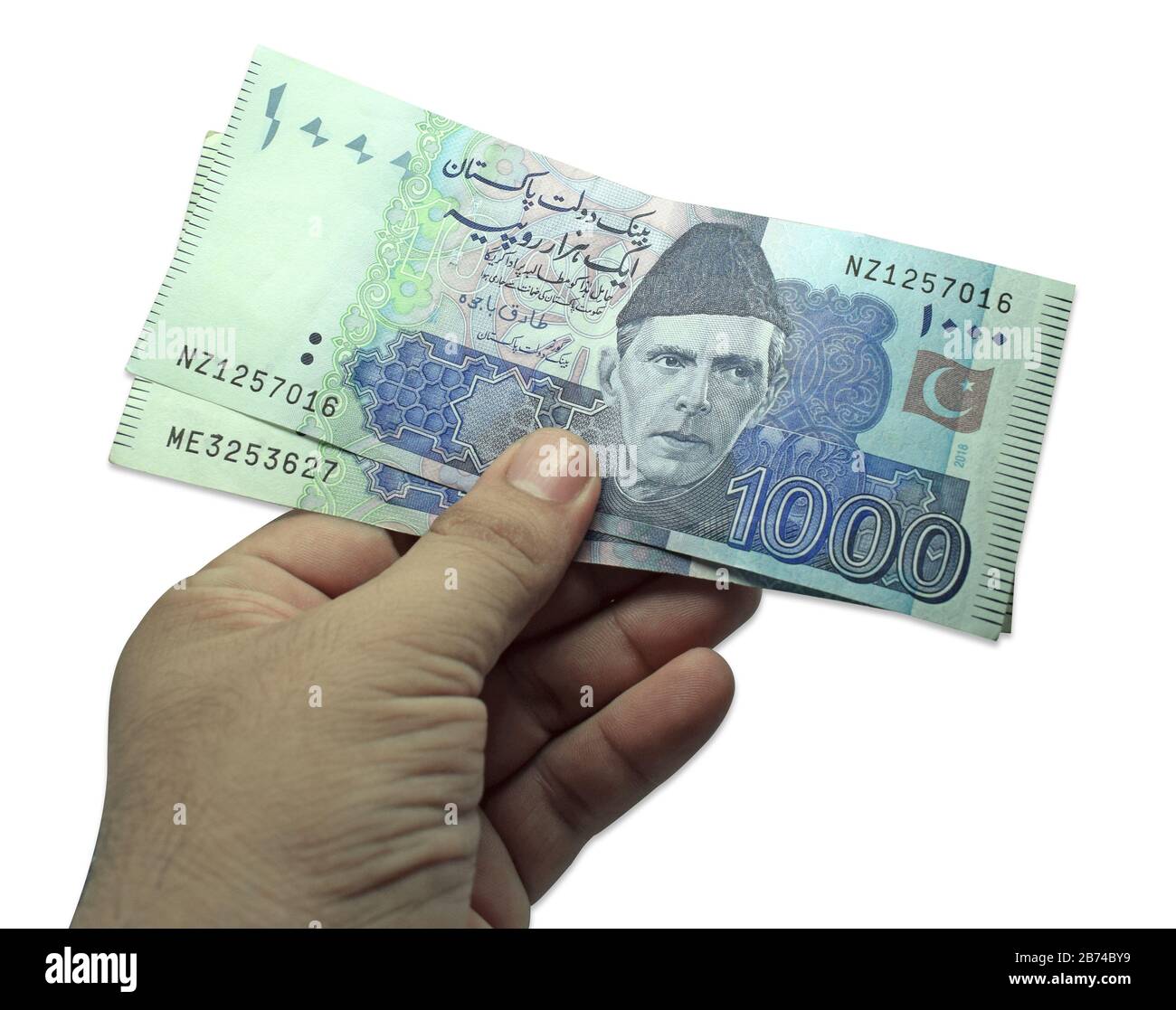 Brown man holding multiple Pakistani currency notes on white background ...