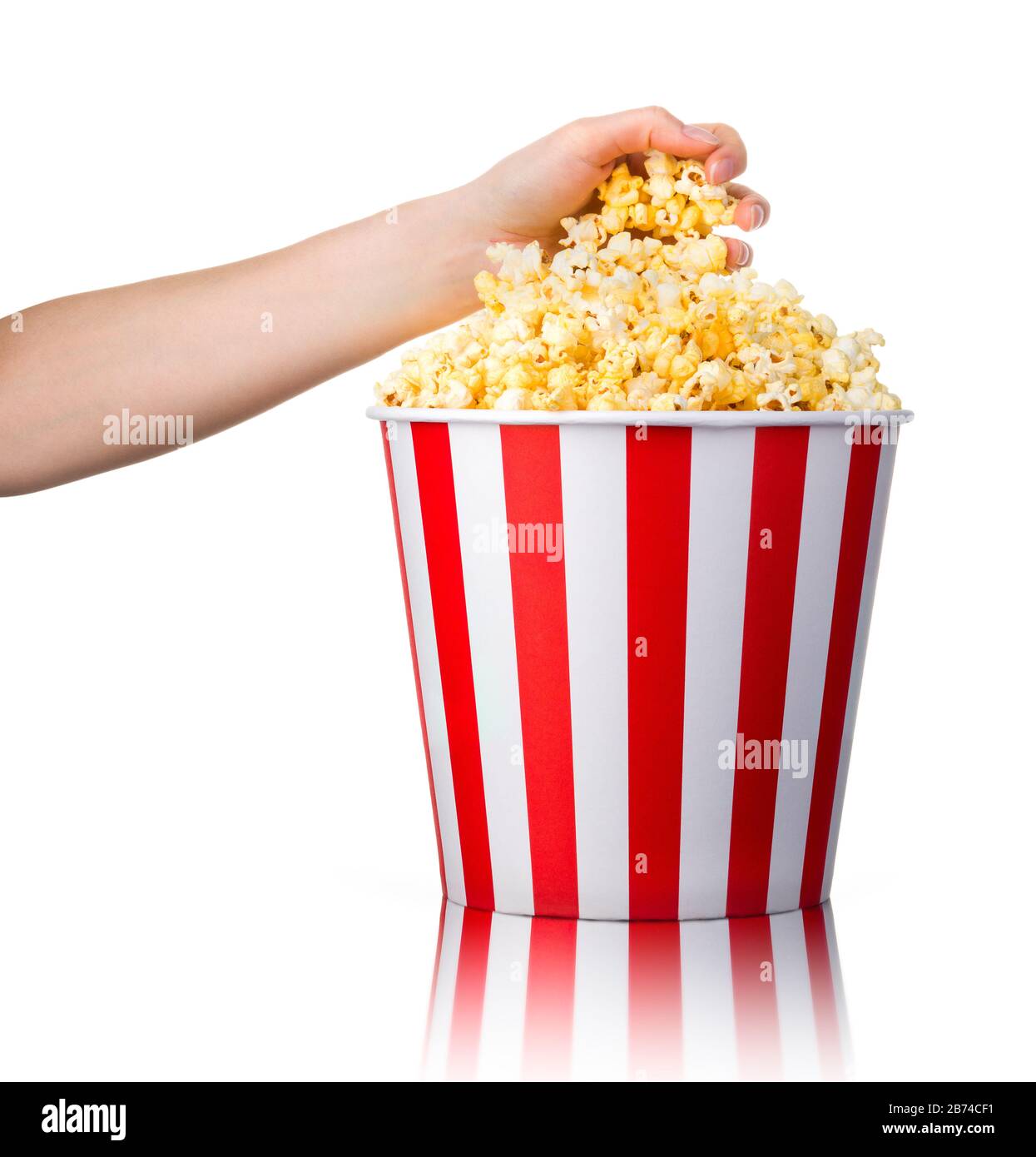 Woman hand picking popcorn from striped bucket isolated on white ...