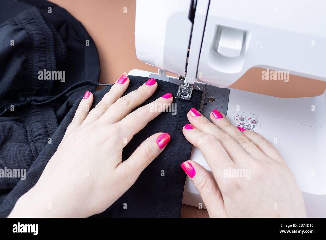 the process of tailoring, woman's hands with a cloth on the sewing ...