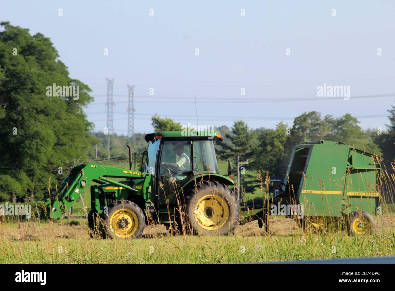 Farmer working with tractor Stock Photo - Alamy