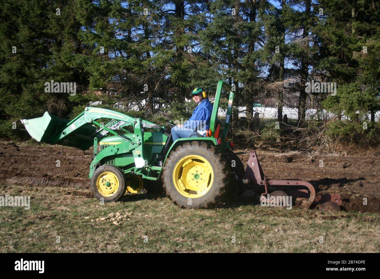 Farmer working with tractor Stock Photo - Alamy