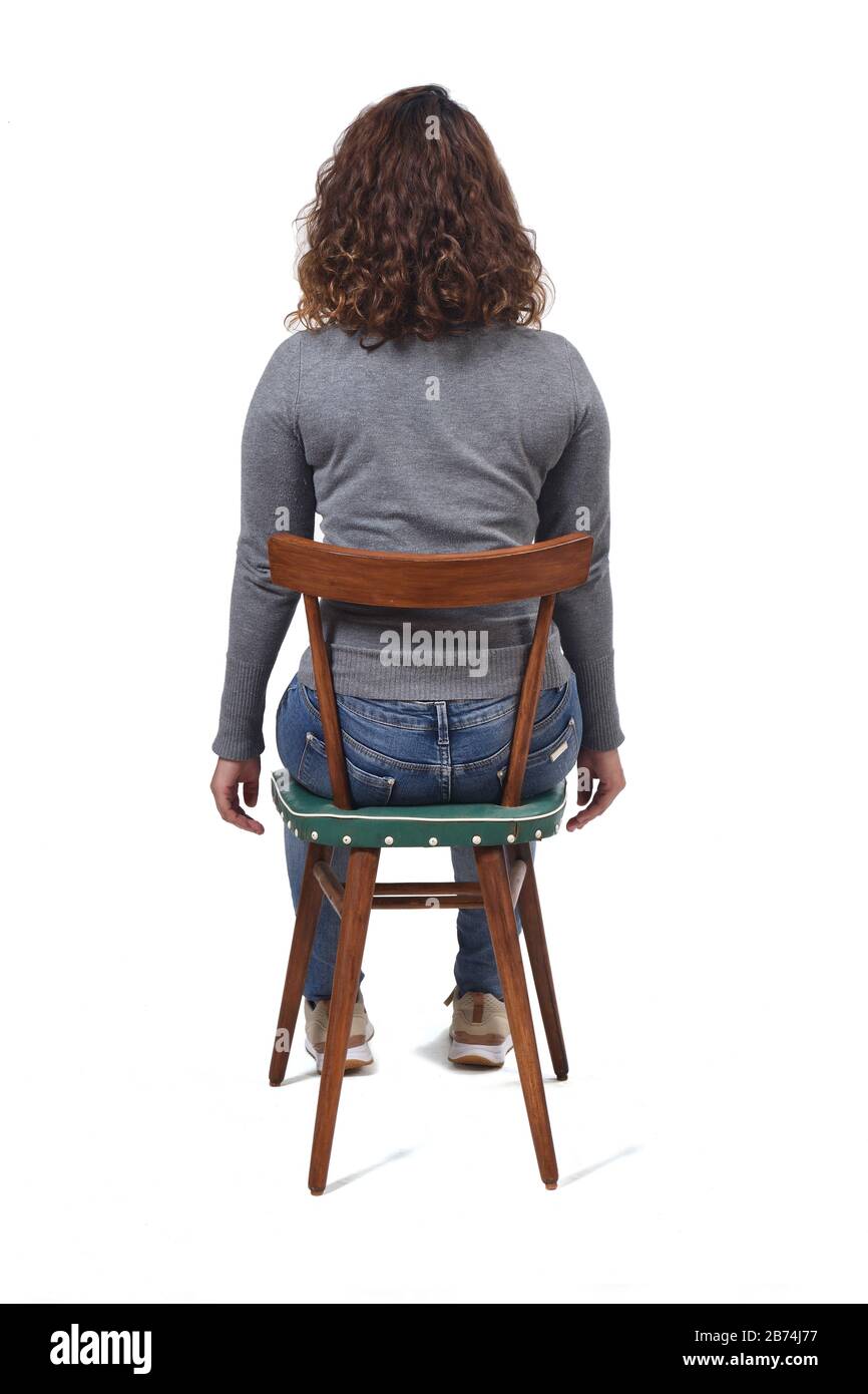 rear view of a woman sitting on chair on white background Stock Photo ...