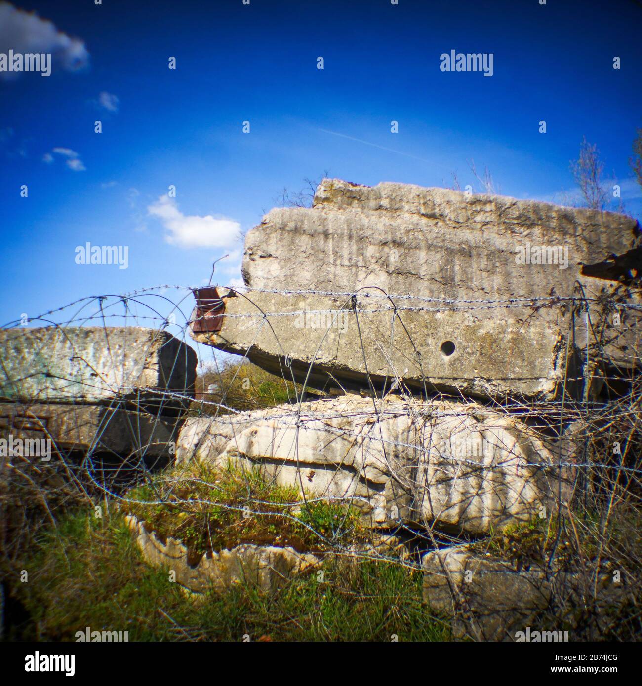 Concrete blocks and barbed wire enclose an abandonned place, digitally ...
