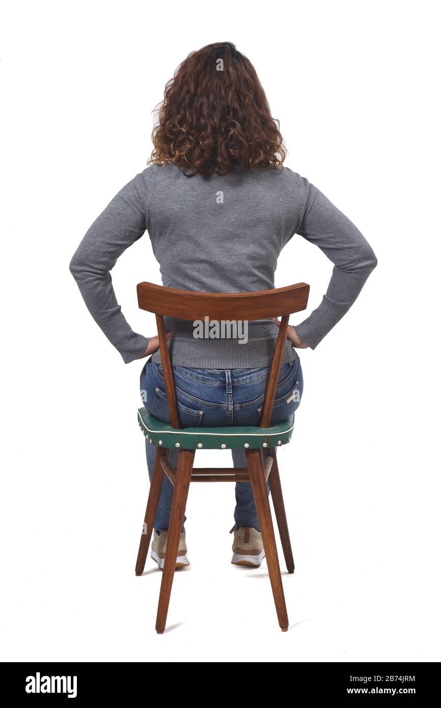 rear view of a woman sitting on chair on white background, hands on hip ...