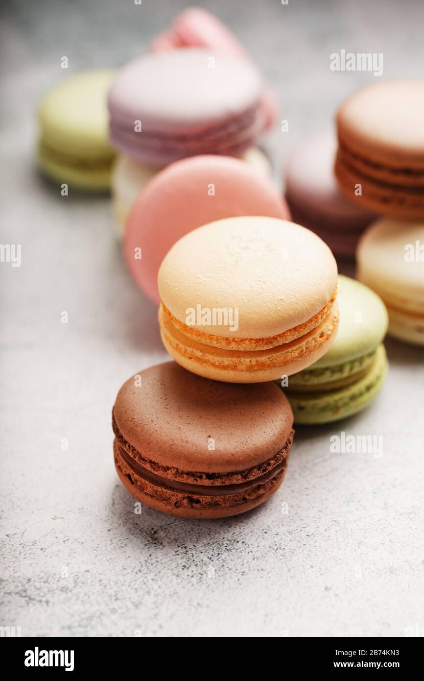 French macaroni cookies of different colors are on the gray table ...