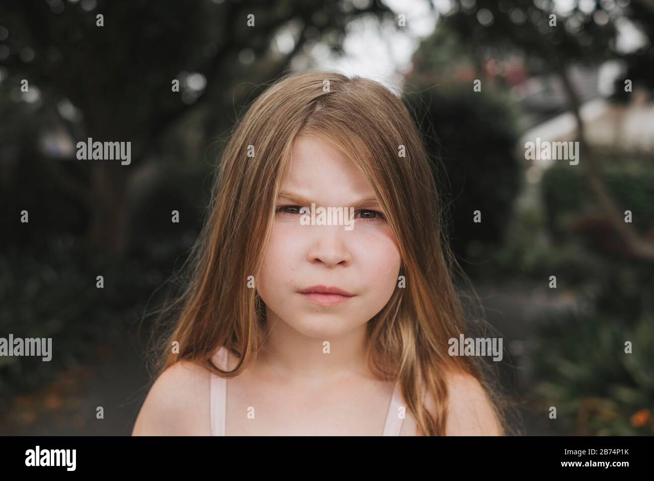 Portrait of a young girl with a serious face standing outside Stock ...