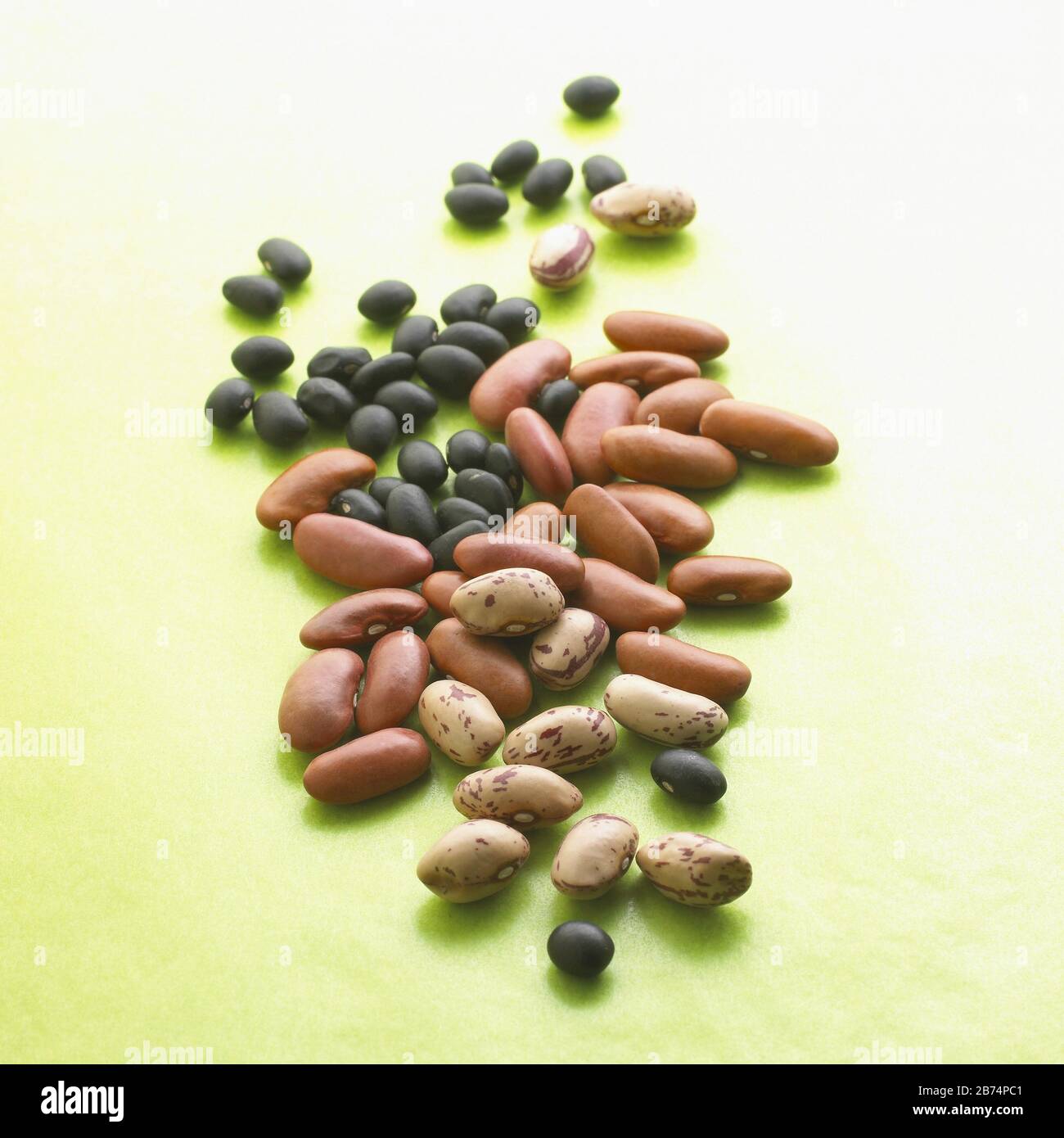 Different kinds of fresh beans on a green background Stock Photo - Alamy