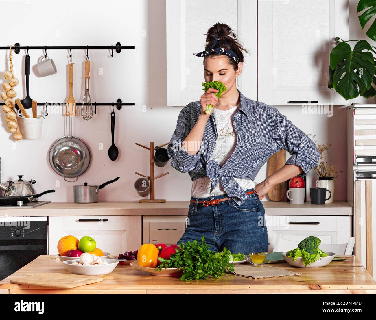 Young and beautiful housewife woman cooking in a kitchen Stock Photo ...