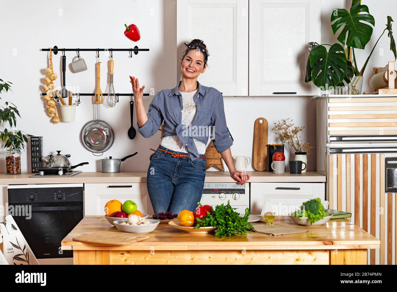 Young and beautiful housewife woman cooking in a kitchen Stock Photo ...