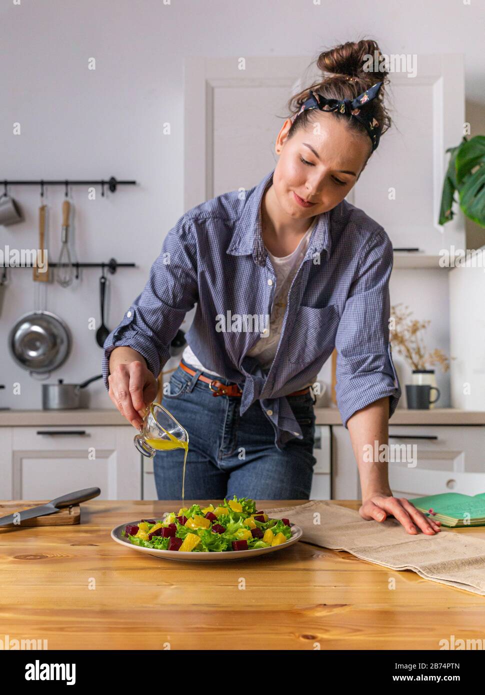 Young and beautiful housewife woman cooking in a kitchen Stock Photo ...