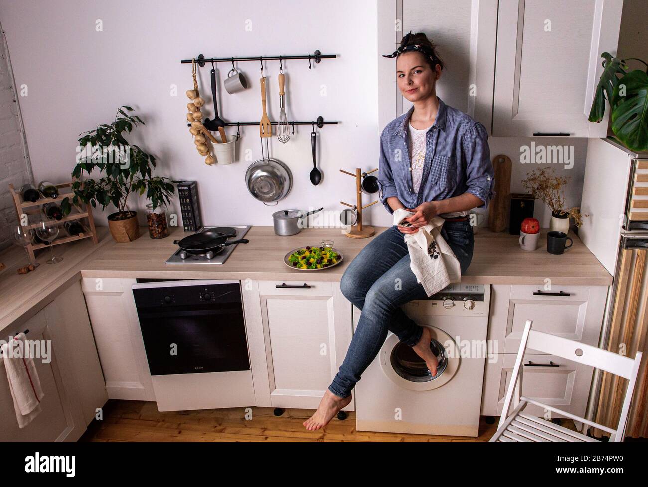 Young and beautiful housewife woman cooking in a kitchen Stock Photo ...