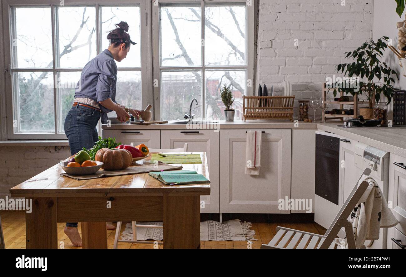 Young and beautiful housewife woman cooking in a kitchen Stock Photo ...