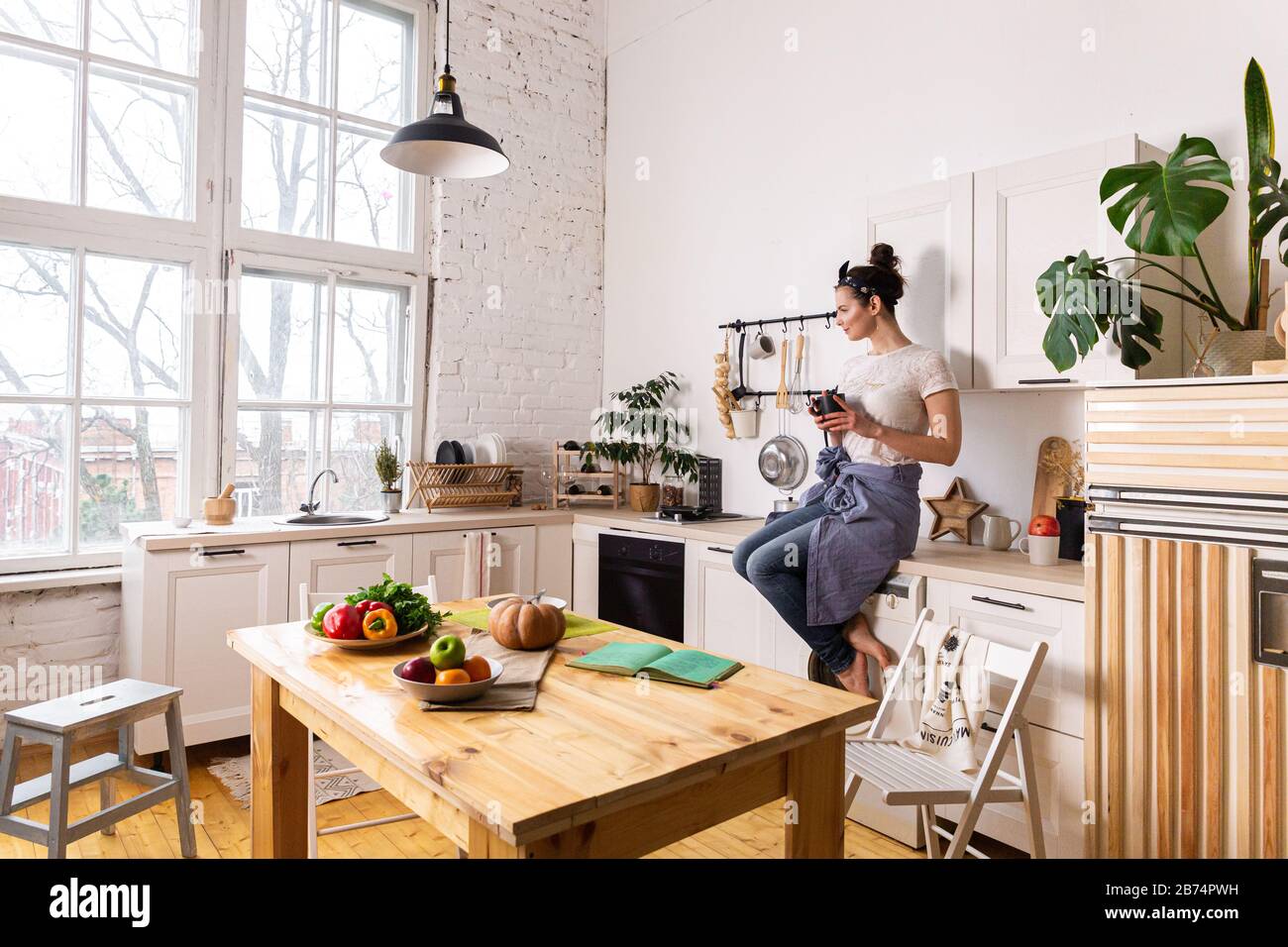Young and beautiful housewife woman cooking in a kitchen Stock Photo ...