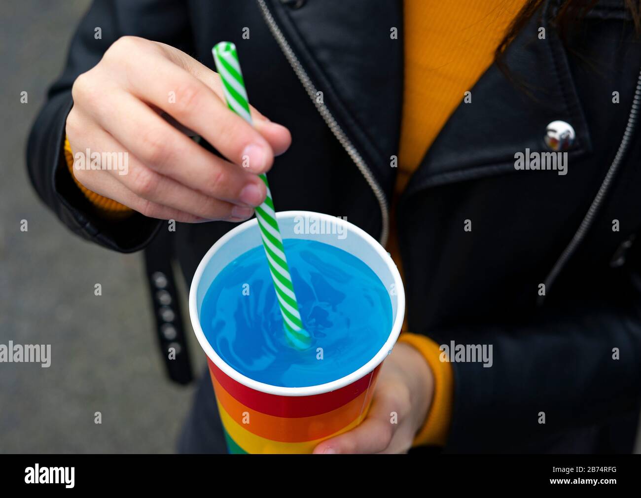 Mixing a blue cocktail with a colorful straw. Cocktail concept and ...