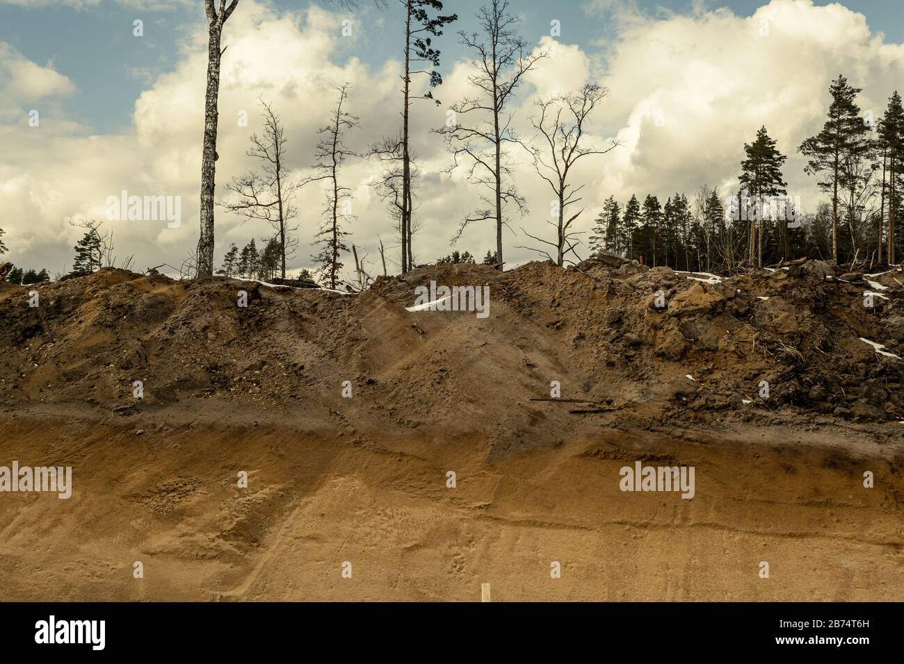 construction site of new road in forest in winter with snow and mud ...