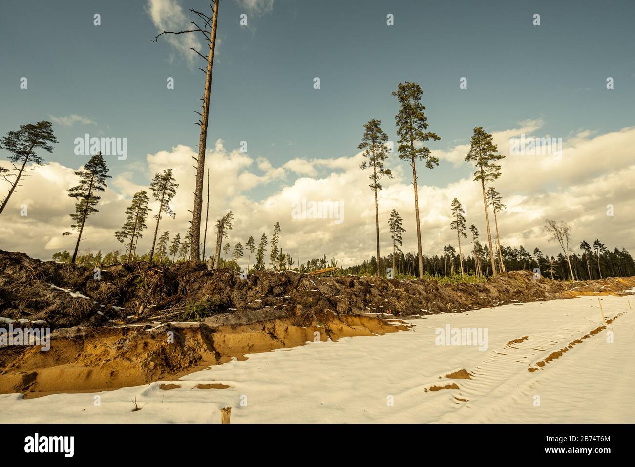 construction site of new road in forest in winter with snow and mud ...