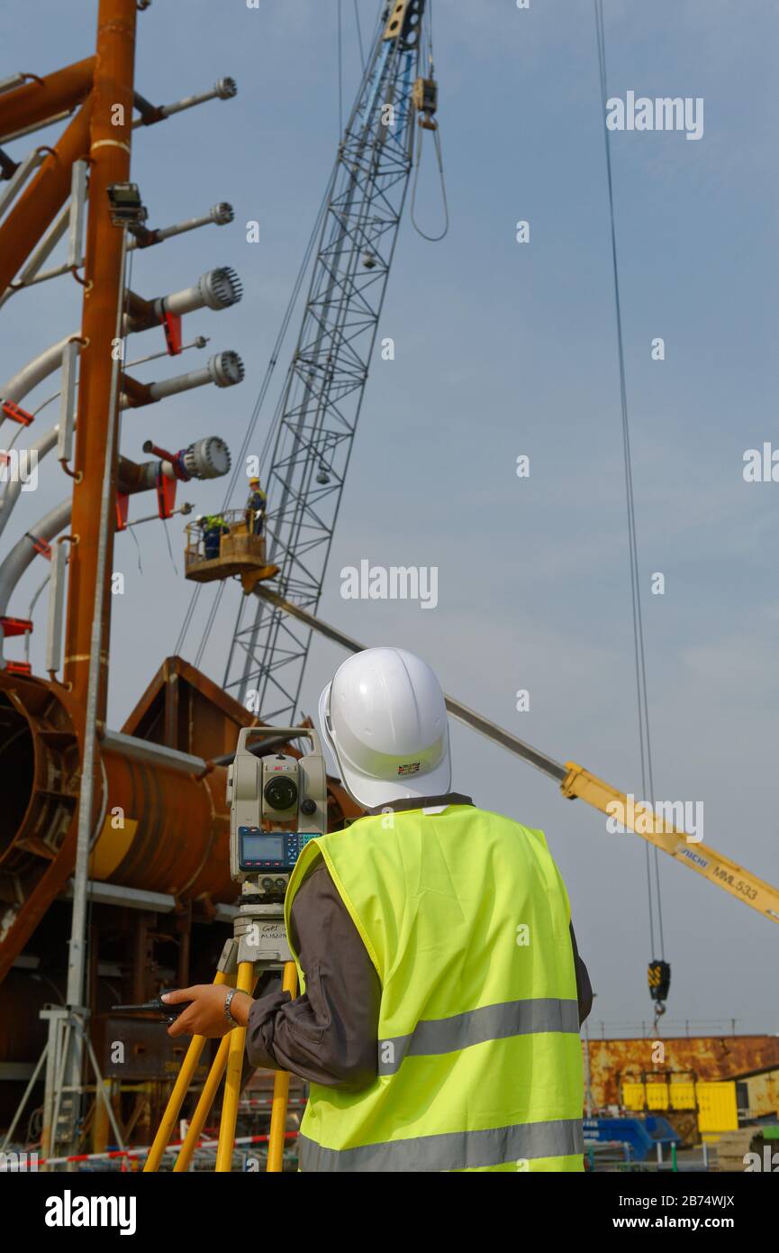 A surveyor working in a fabrication yard for an offshore oil and gas ...