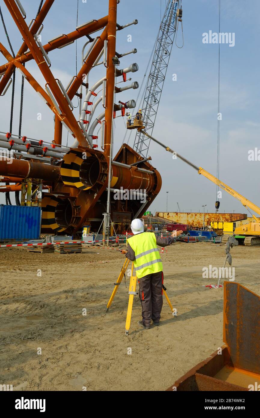 A surveyor working in a fabrication yard for an offshore oil and gas ...