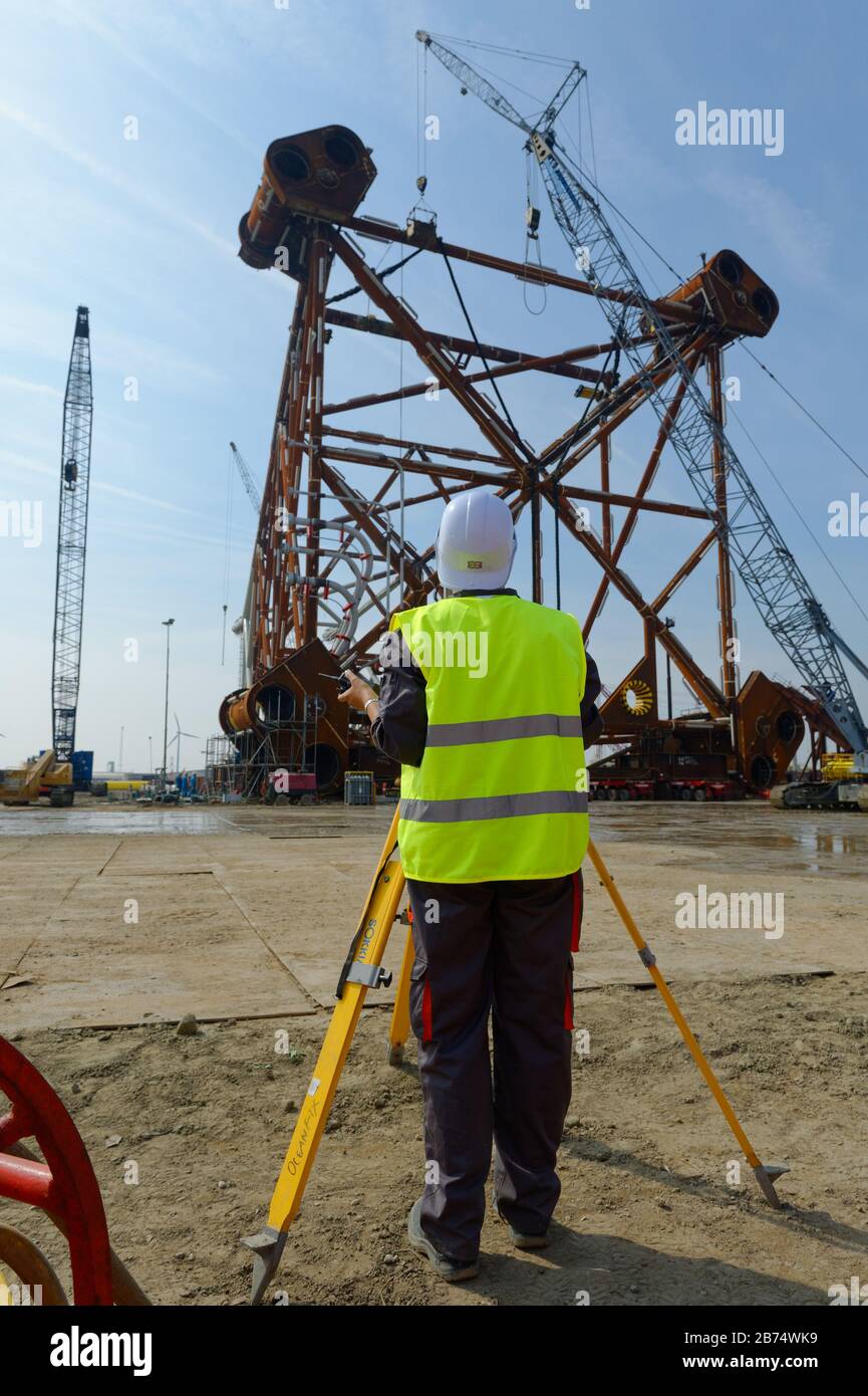 A surveyor working in a fabrication yard for an offshore oil and gas ...