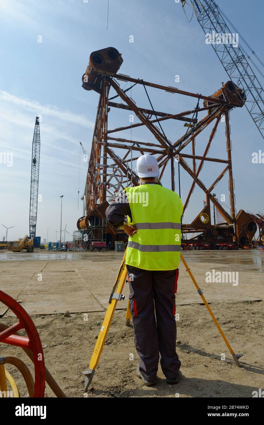 A surveyor working in a fabrication yard for an offshore oil and gas ...