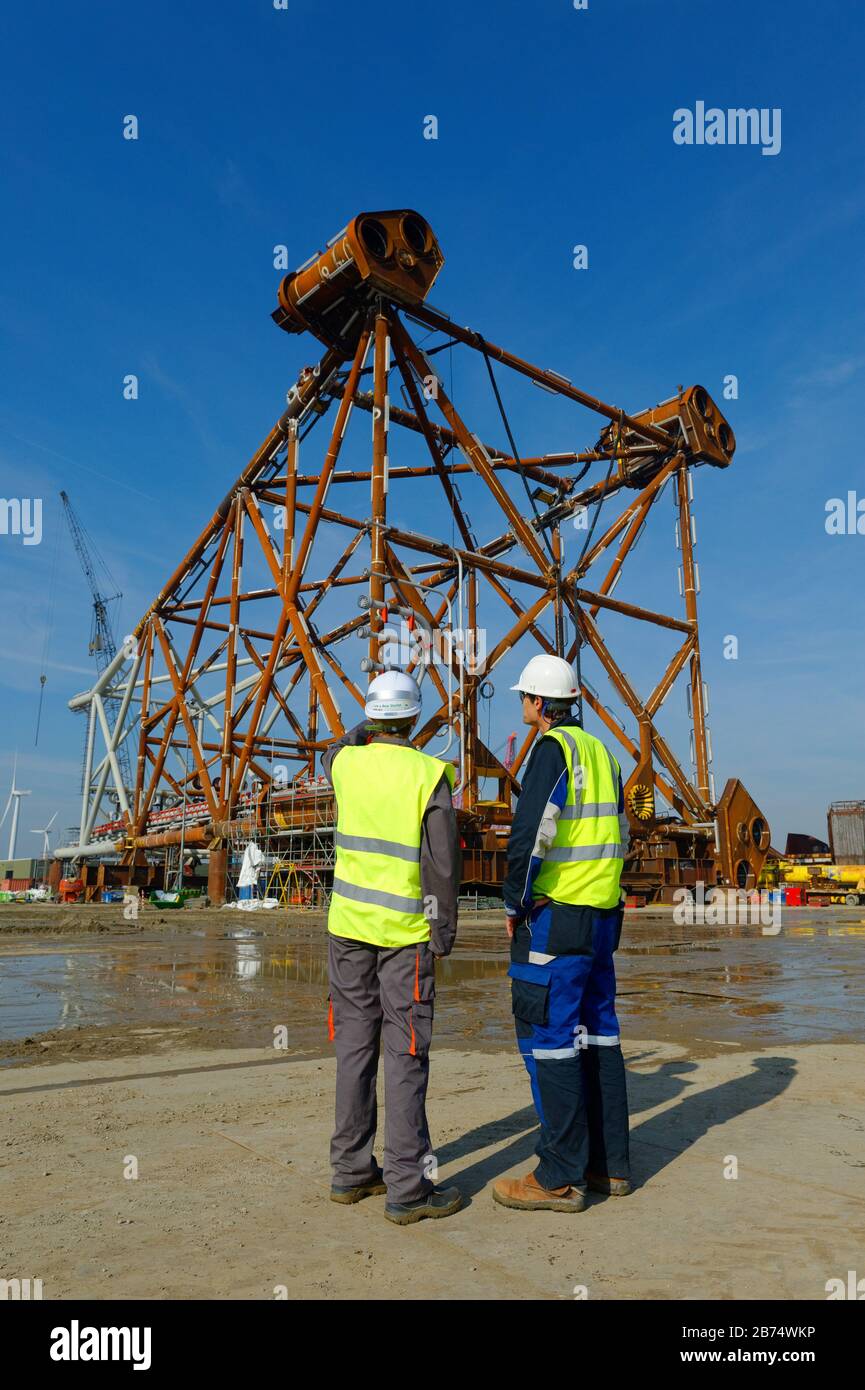 Construction workers in front of an offshore oil and gas platform also ...