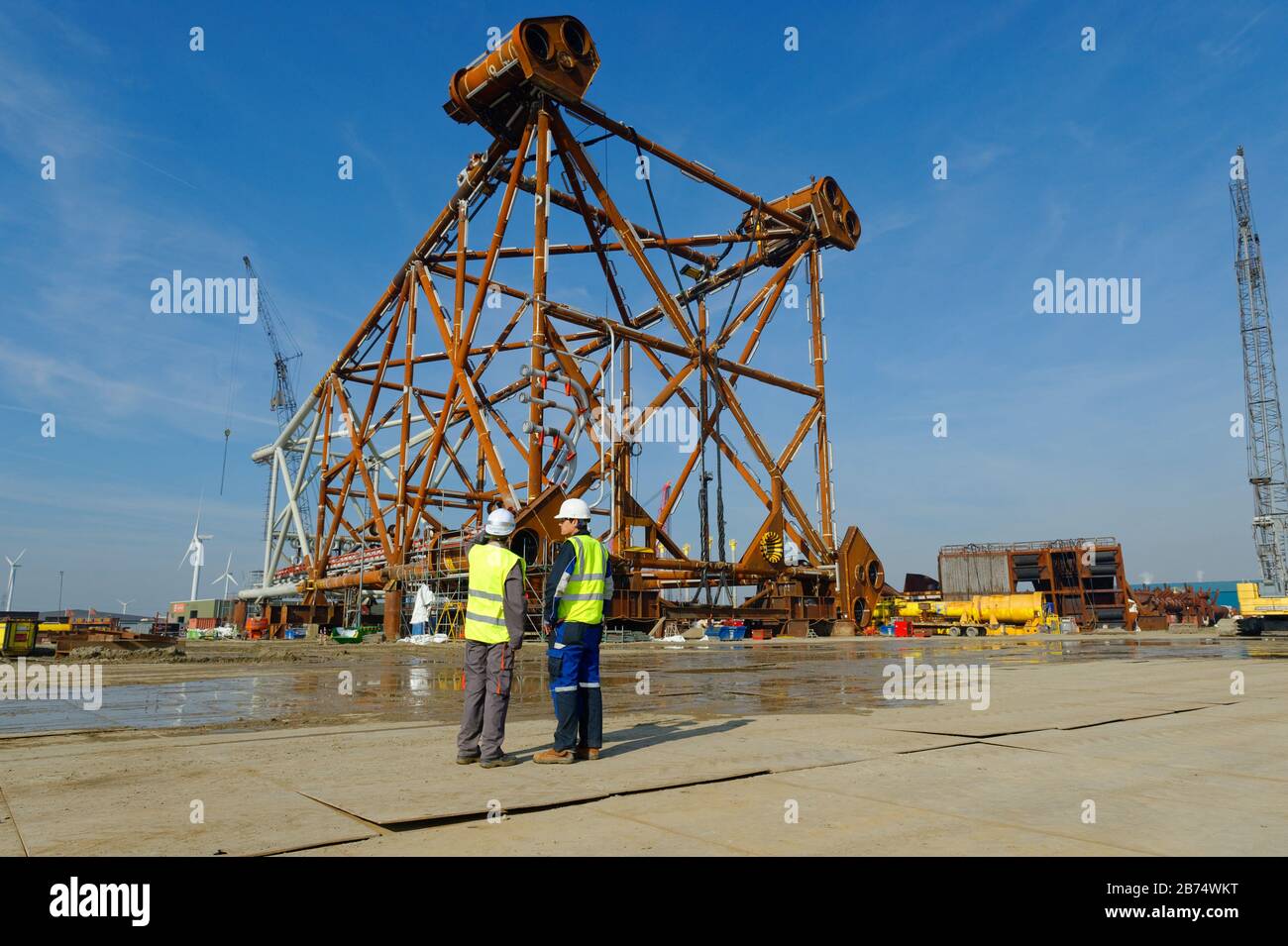 Construction workers in front of an offshore oil and gas platform also ...