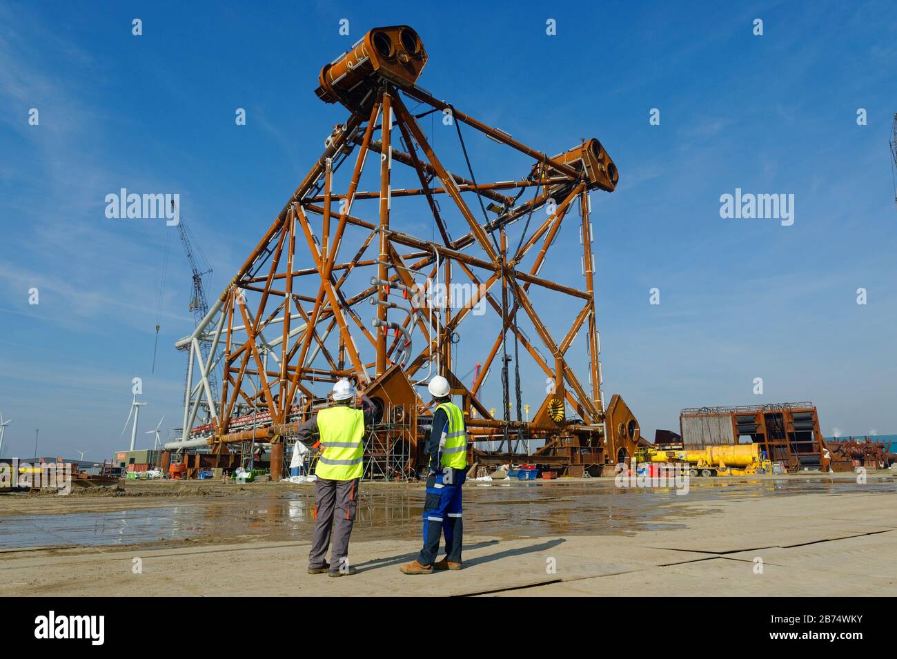 Construction workers in front of an offshore oil and gas platform also ...
