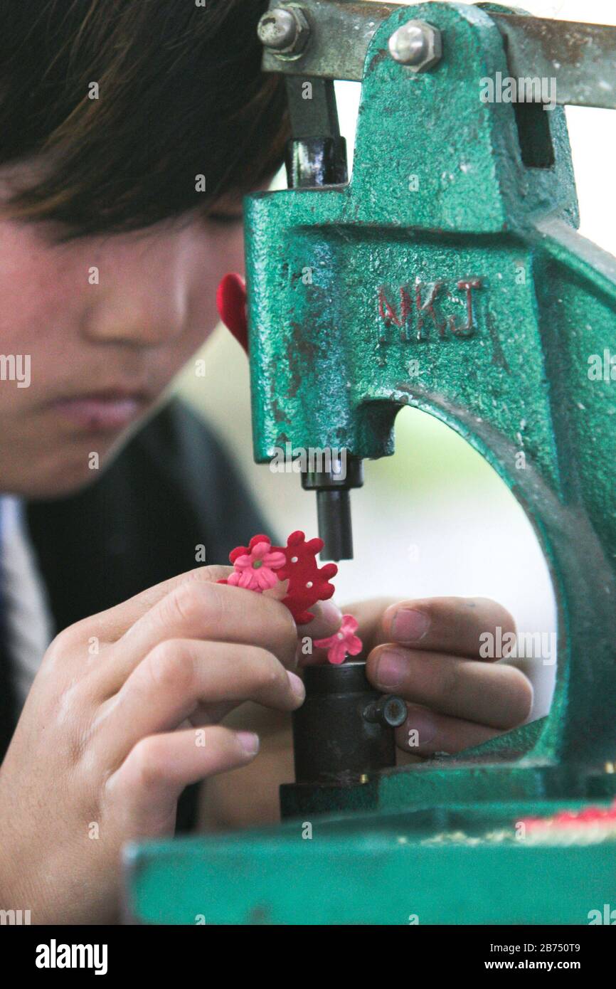 Workers make Remembrance red poppy flower at Good Luck Factory in ...